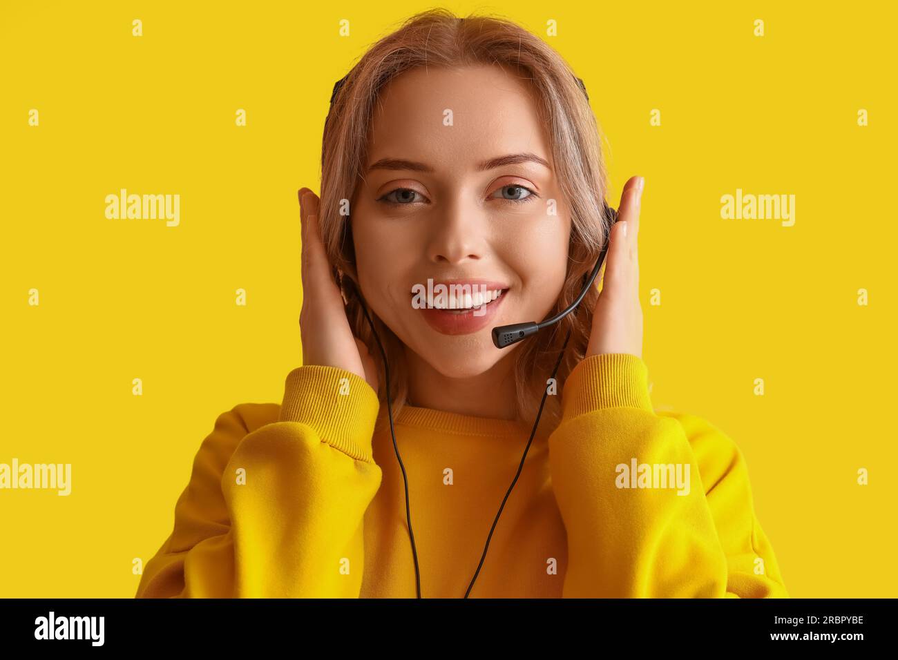 Female technical support agent on yellow background Stock Photo - Alamy