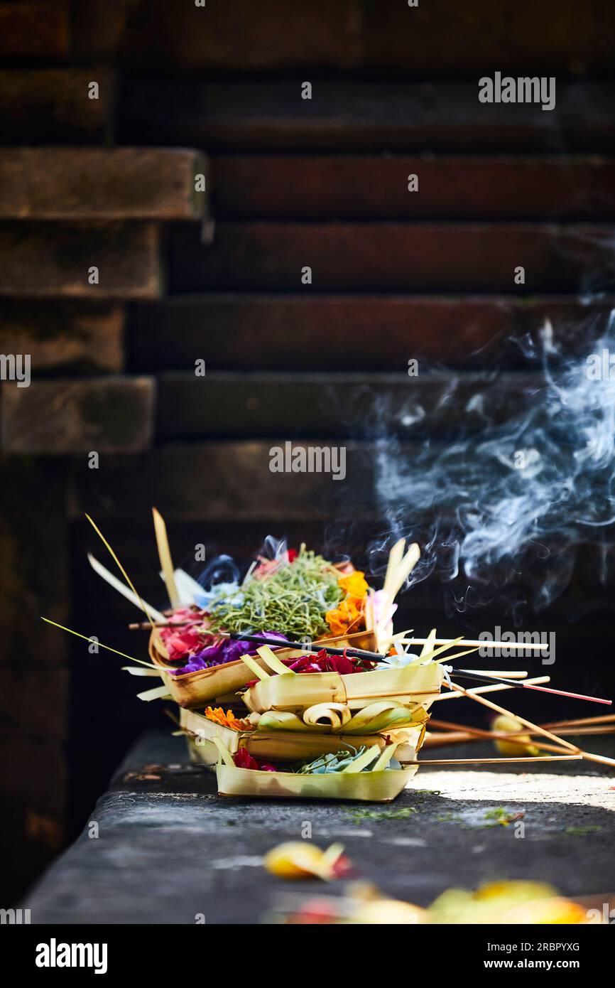 Offerings made of palm leaves with flowers and incense on the steps of ...
