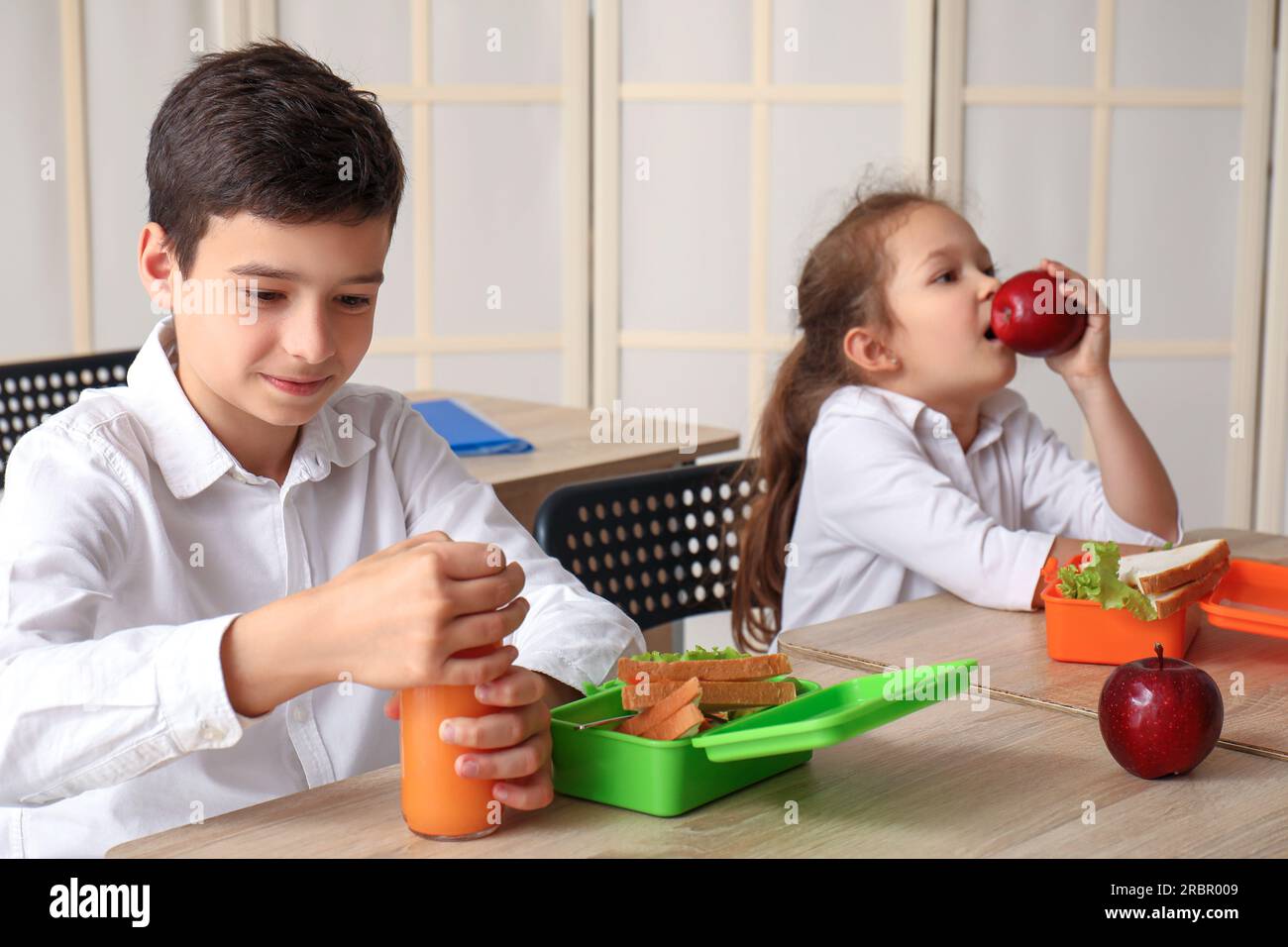 Little children eating lunch in classroom Stock Photo - Alamy
