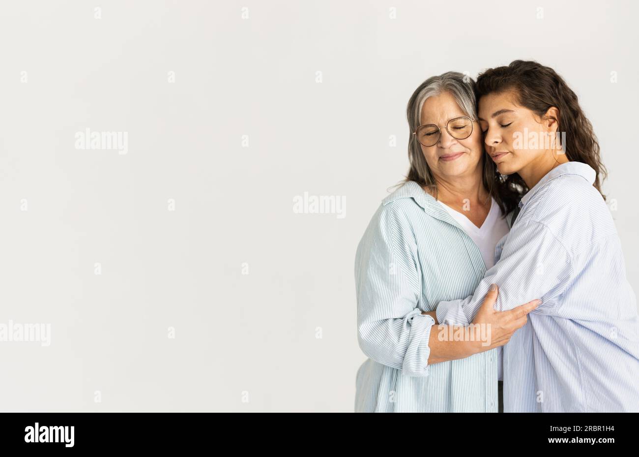 Calm happy adult woman hugging old lady, enjoy free time, visit ...