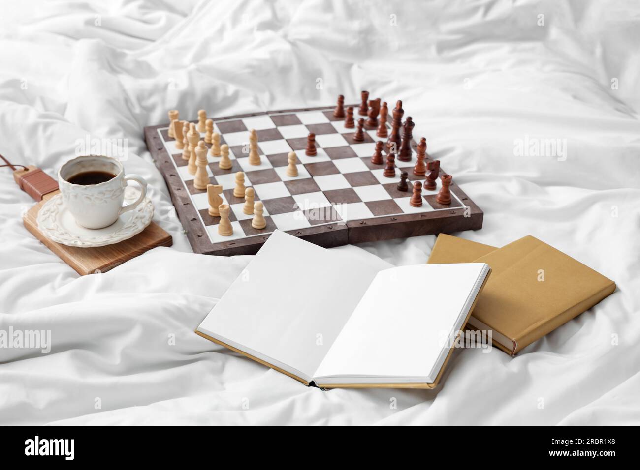 Chess board with books and cup of coffee on bed Stock Photo - Alamy