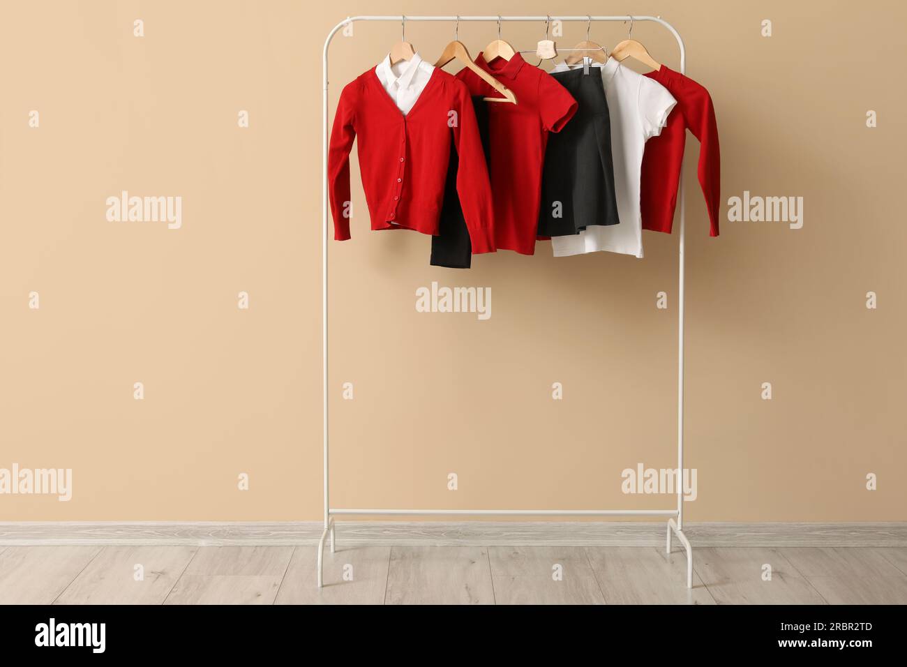 Rack with stylish school uniform against color wall Stock Photo - Alamy
