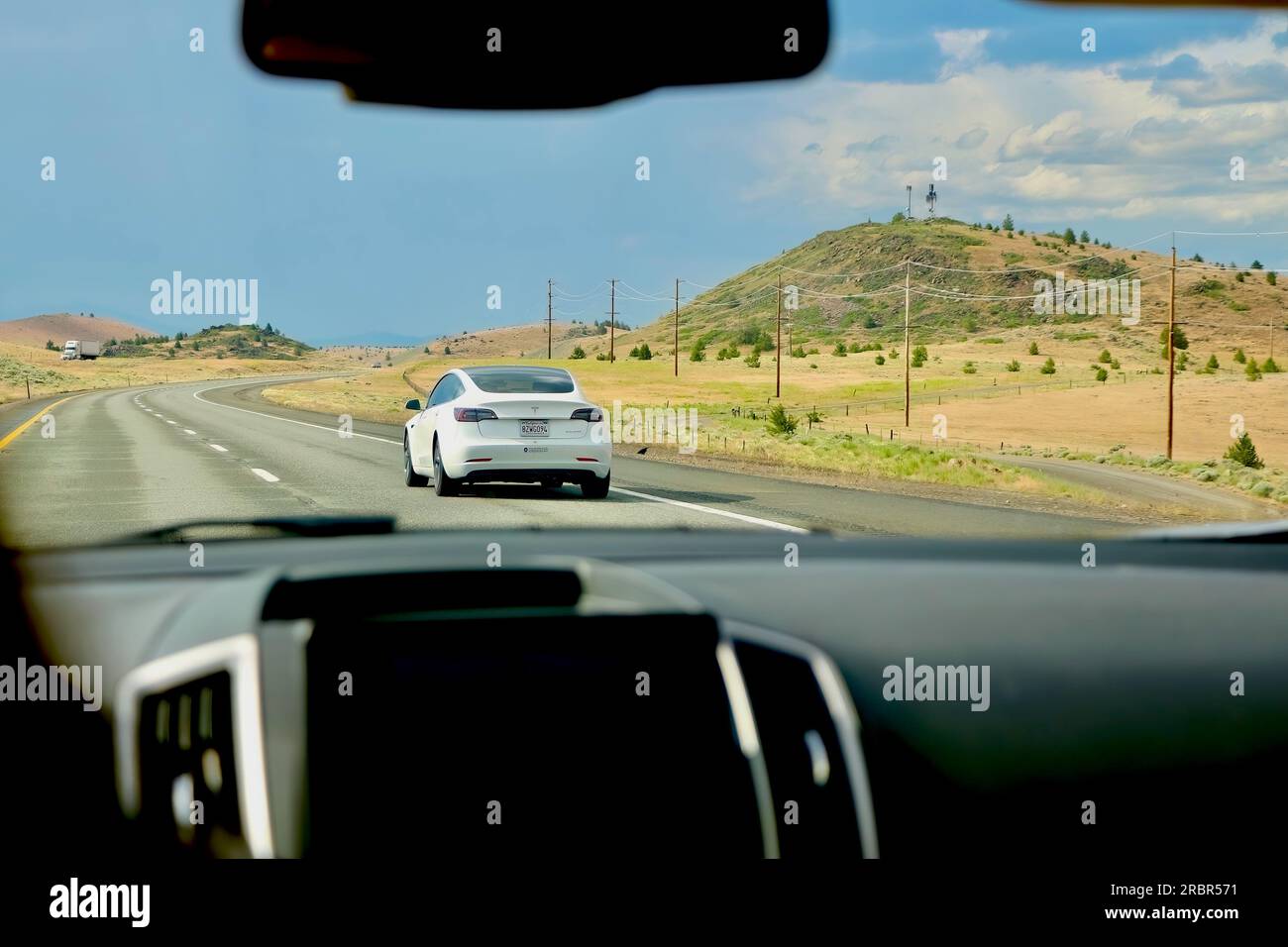 A white Tesla Model 3 driving north on Interstate 5 seen from inside a ...