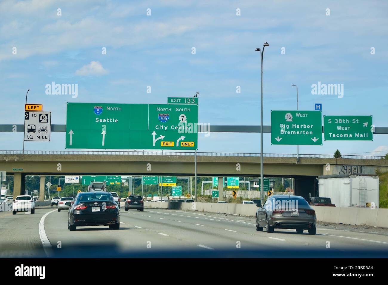 View of Exit 133 road signs from inside a car of traffic heading north on Interstate 5 towards ...