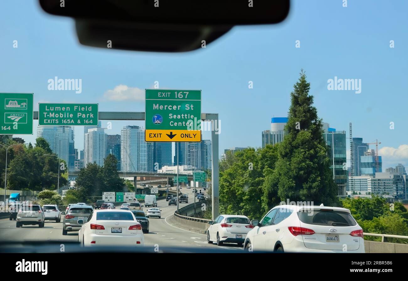 View of the city skyline road signs and skyscrapers from inside a car of traffic heading north ...