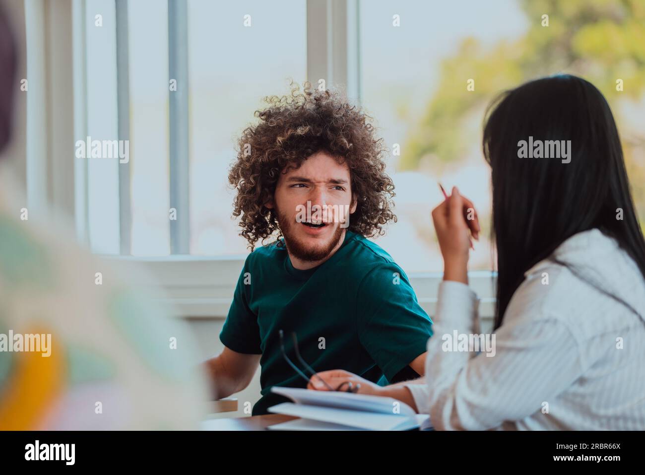 A group of diverse students engages in lively discussion as they ...