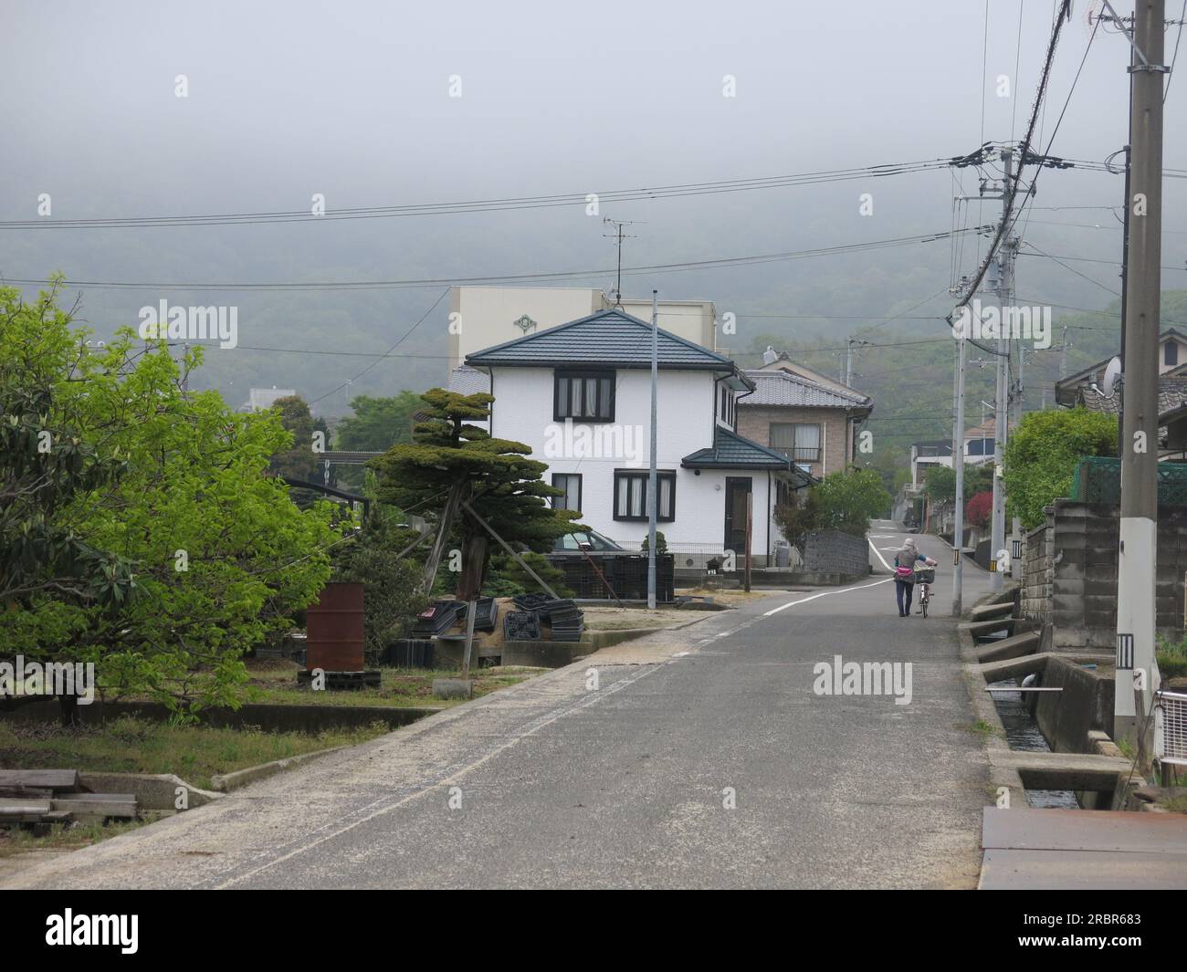 A view along the road with a drainage channel to the side & a Japanese ...