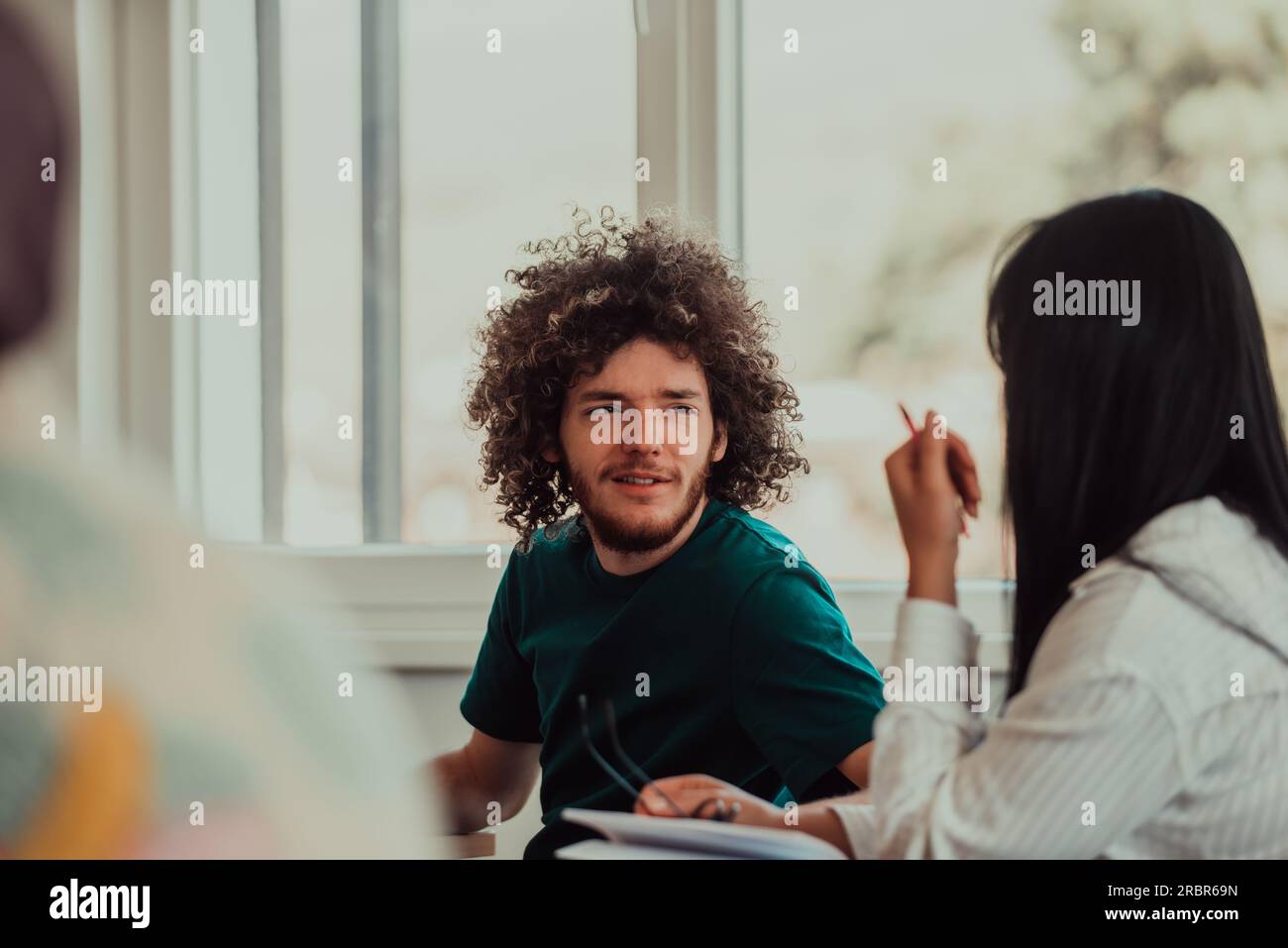 A group of diverse students engages in lively discussion as they ...