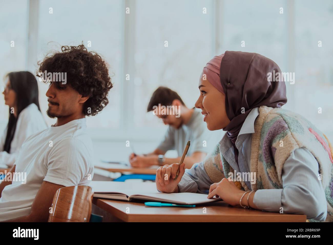 A group of diverse students engages in lively discussion as they ...