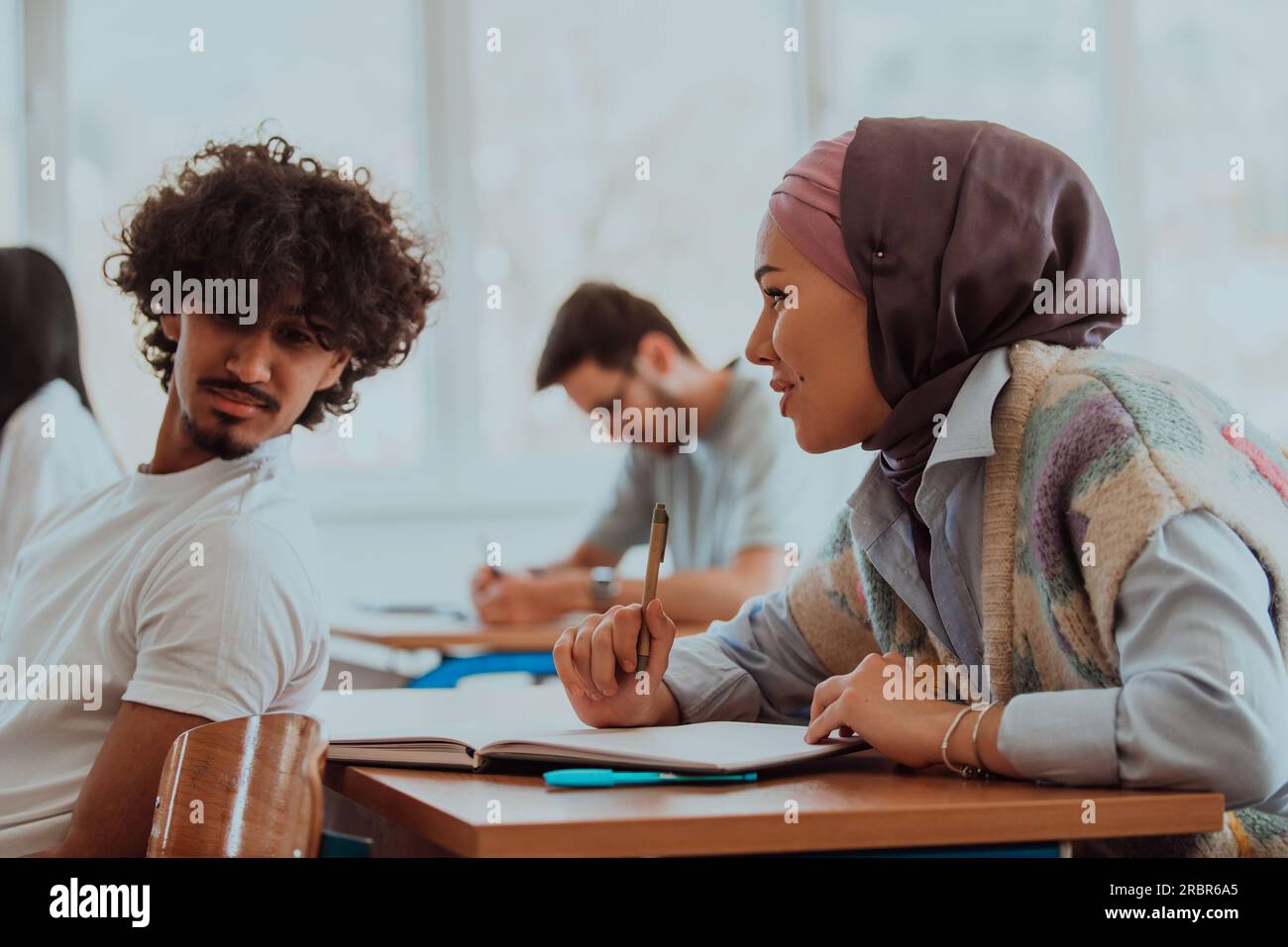 A group of diverse students engages in lively discussion as they ...