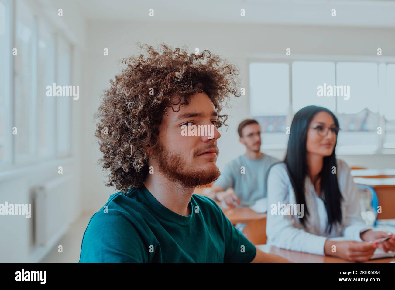 A group of diverse students engages in lively discussion as they ...