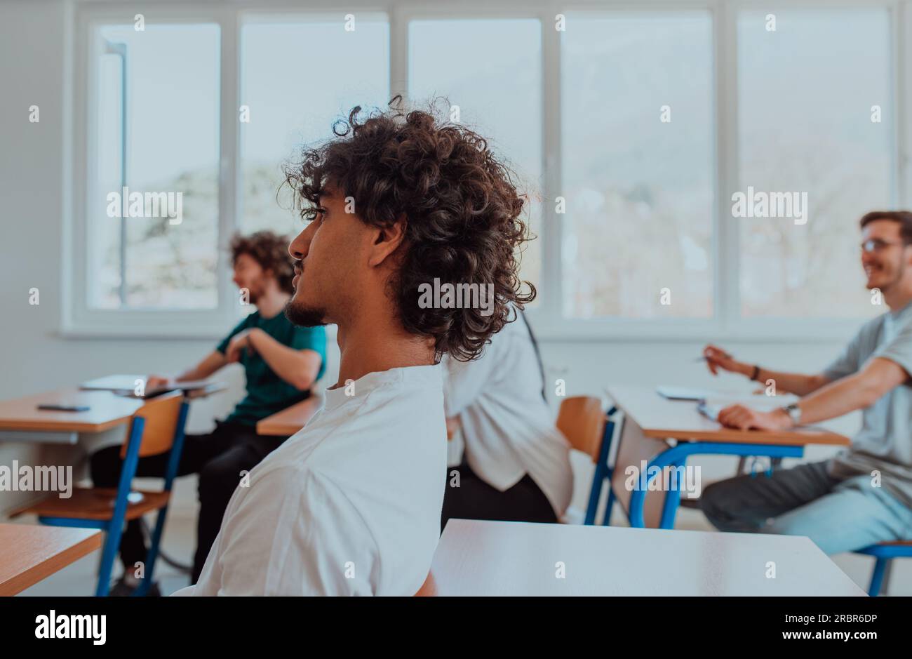 A group of diverse students engages in lively discussion as they ...