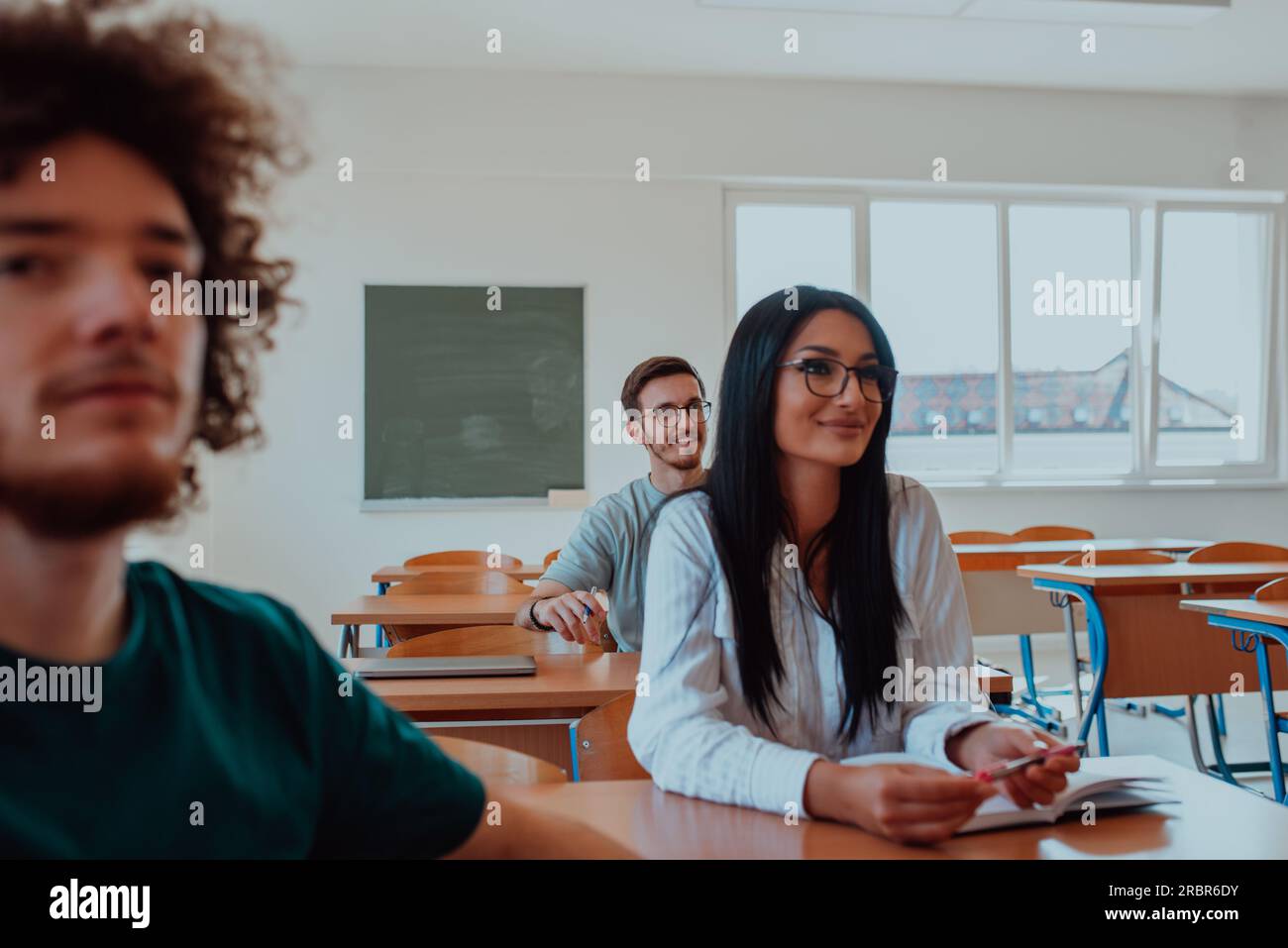 A group of diverse students engages in lively discussion as they ...