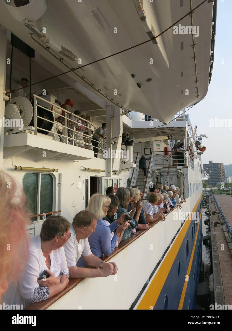 UK passengers on a cruise ship are lined up on deck to watch the ...