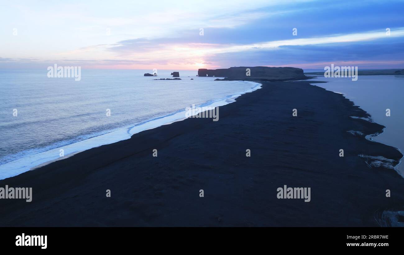 Aerial view of black sand beach with mountains and big stones in ...
