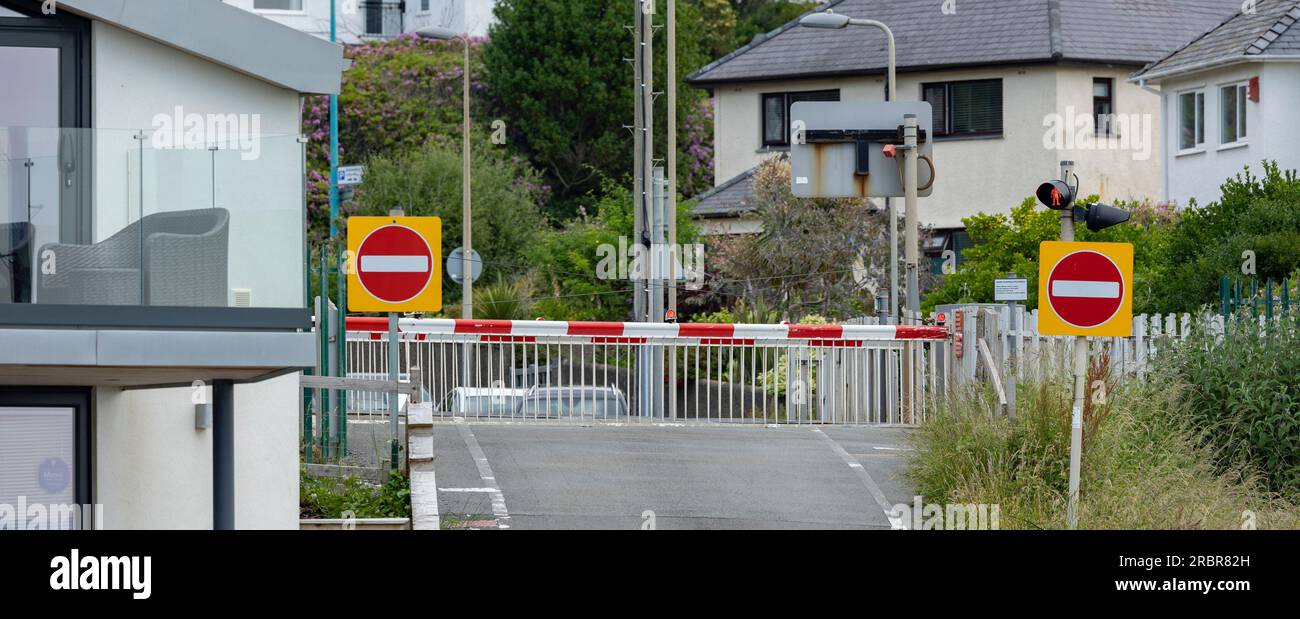 Automated urban level crossing with the barriers down and flashing red ...