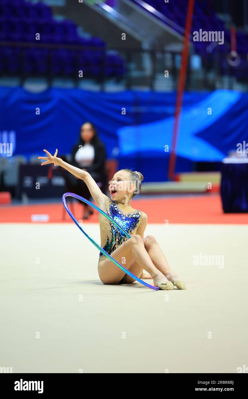 Beautiful girl gymnast performs with the hoop stretch Stock Photo - Alamy