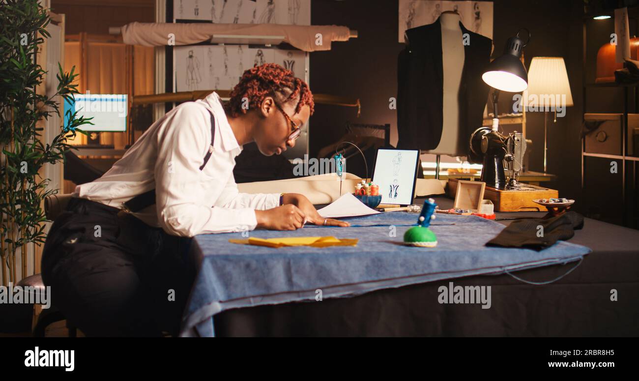 Seamstress using measuring tape in atelier, working with tailoring ...