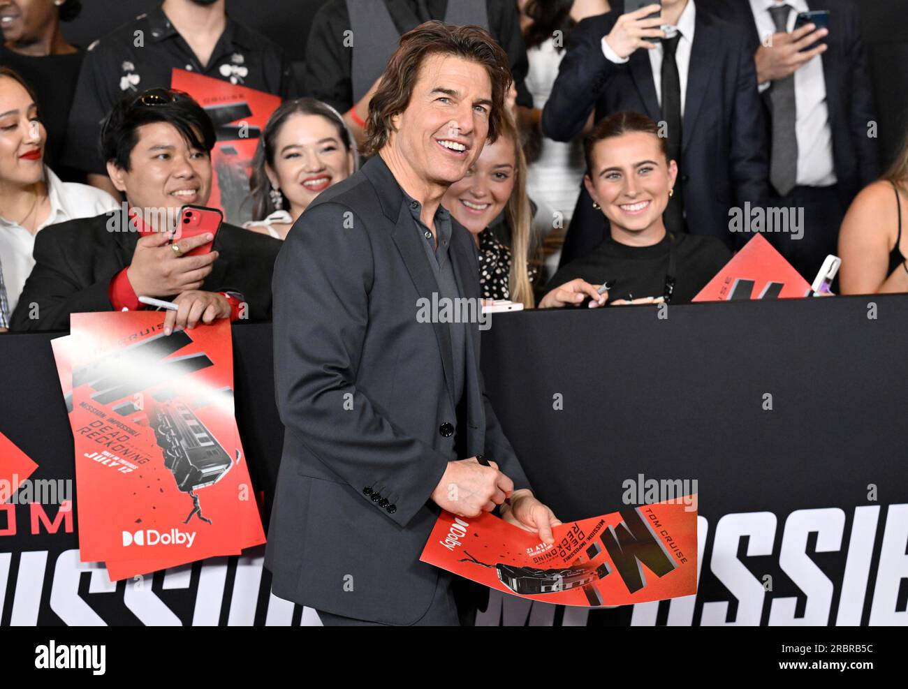 Tom Cruise signs an autograph as he attends the premiere of "Mission ...