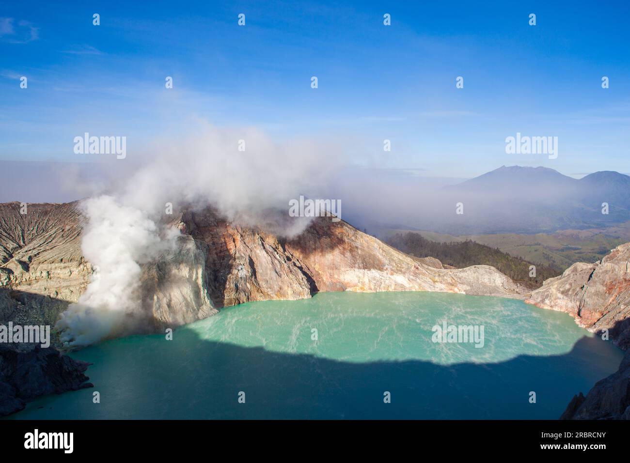 Colorful Ijen volcano crater lake and Raung volcano in the background ...