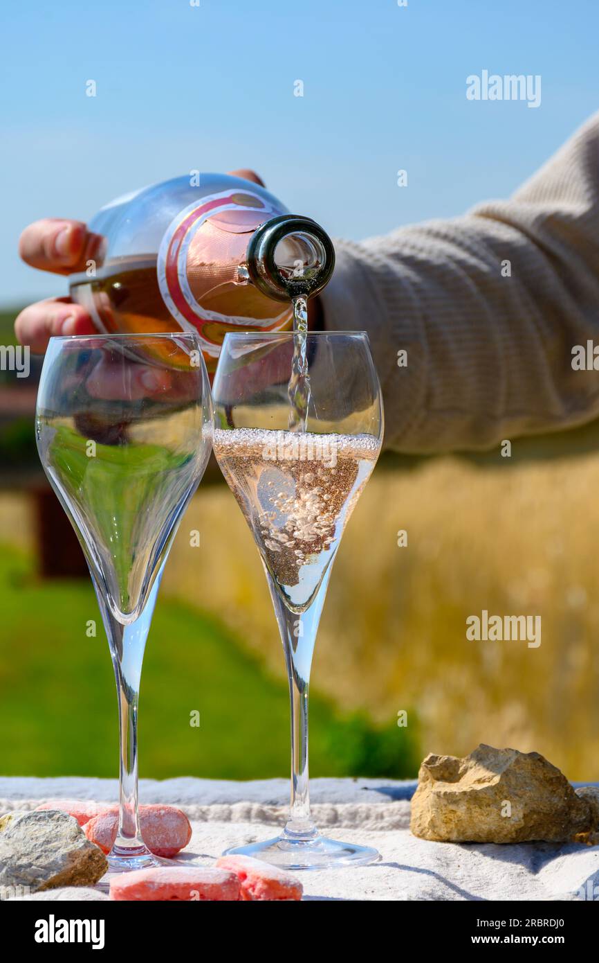 Pouring of grand cru sparkling rose wine with bubbles champagne with ...