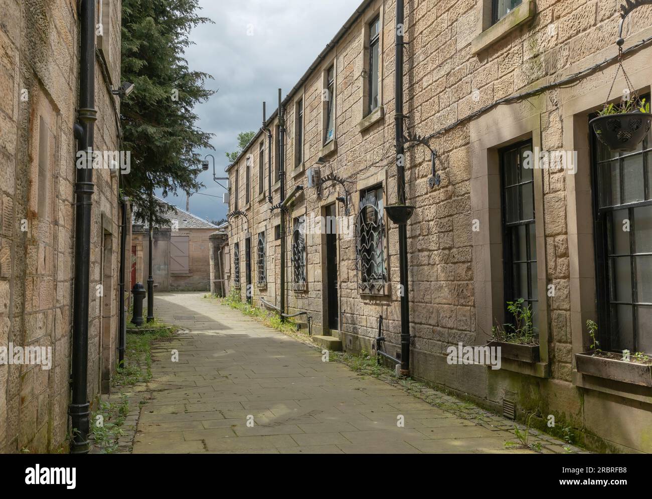 Empty Alleyway with no one around with ornate window bars and a grey ...