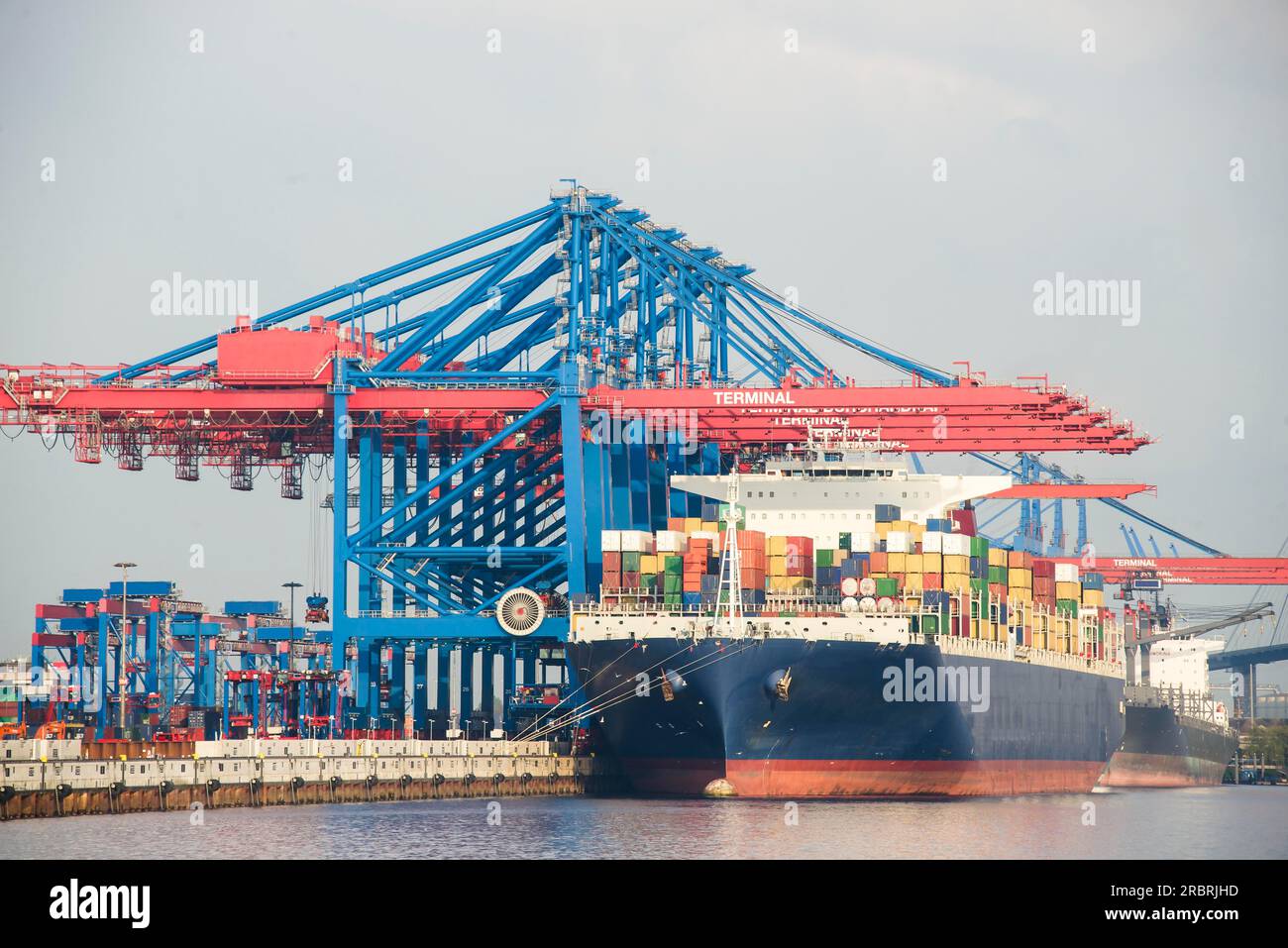 A big container ship in the port terminal is loaded Stock Photo - Alamy