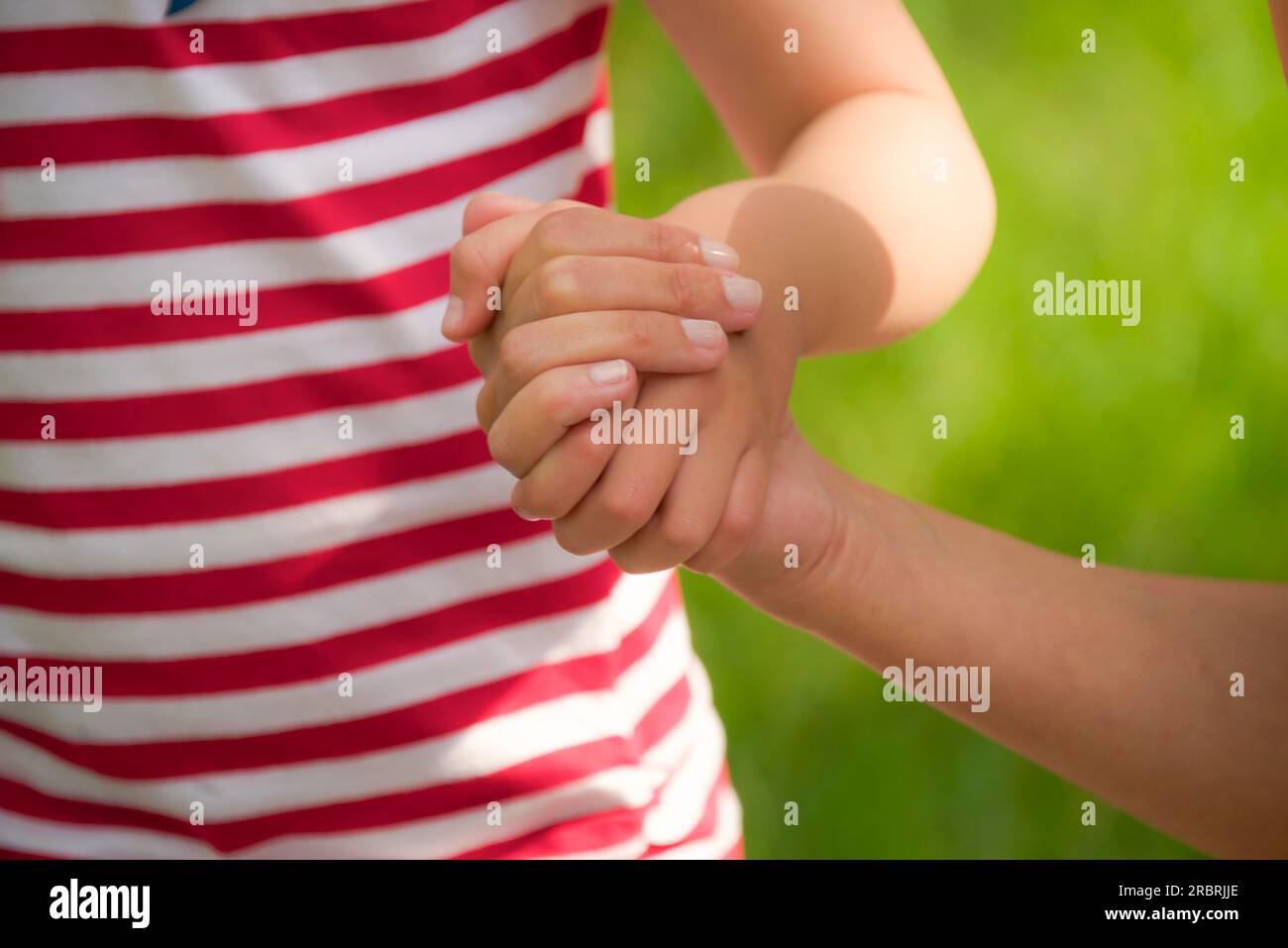 Child takes mothers hand Stock Photo - Alamy