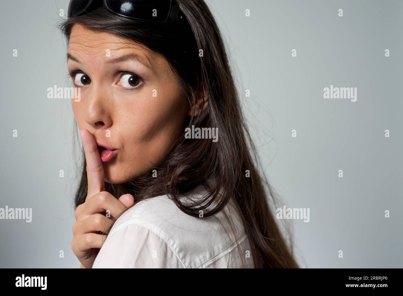 Woman putting finger lips hi-res stock photography and images - Alamy