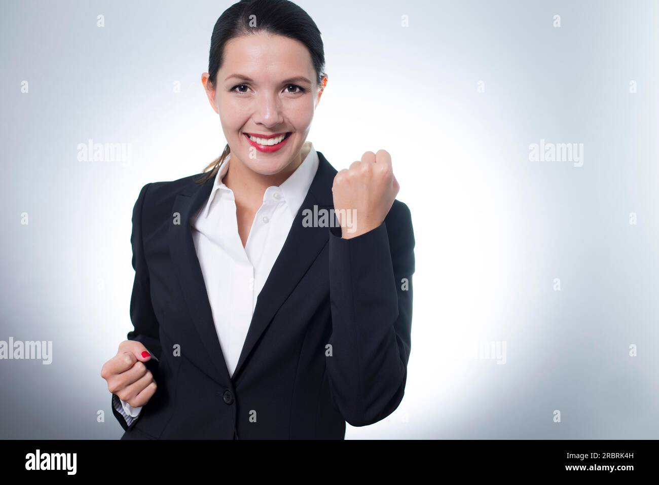 Beautiful jubilant young businesswoman cheering with a beaming ...