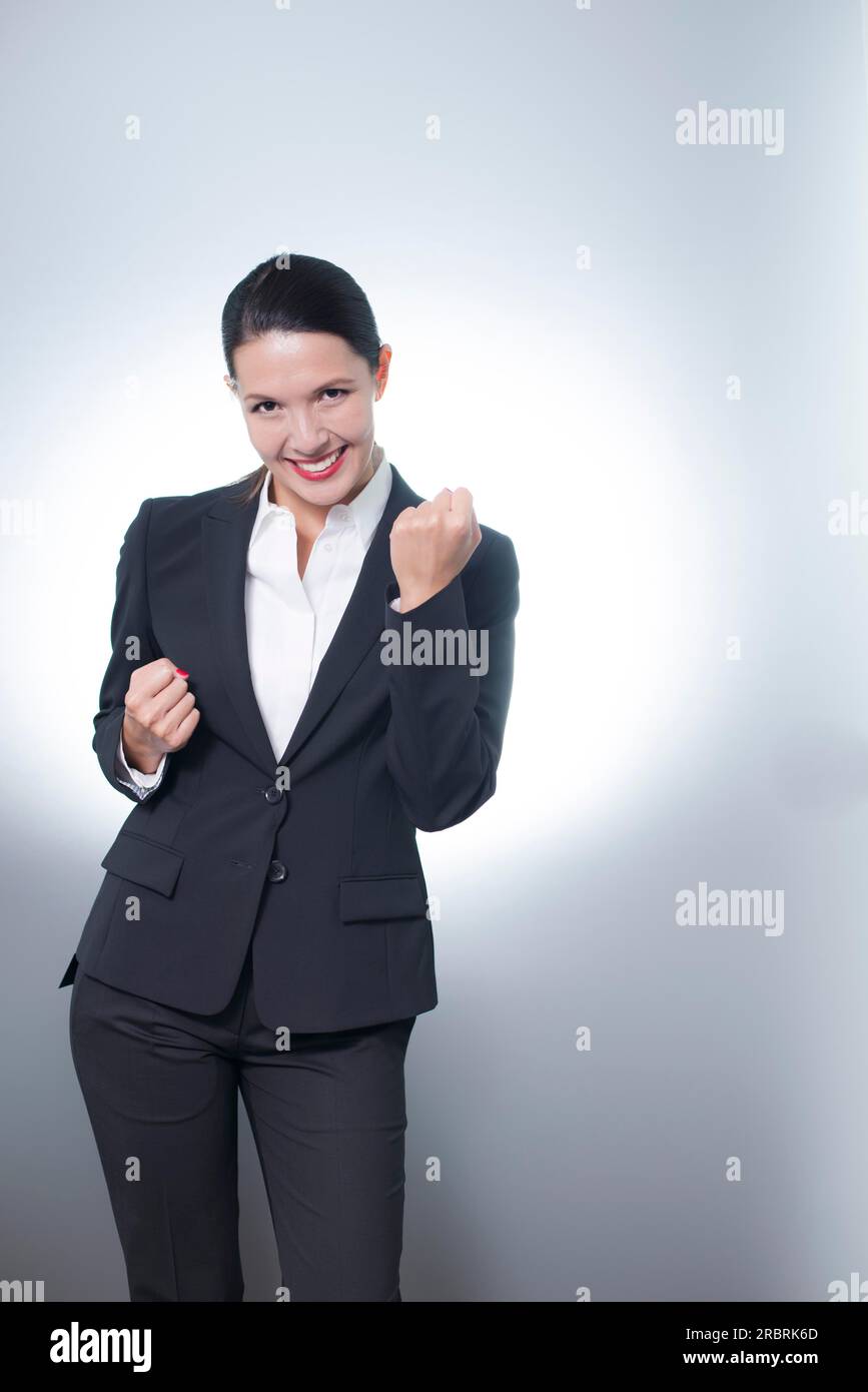 Beautiful jubilant young businesswoman cheering with a beaming ...