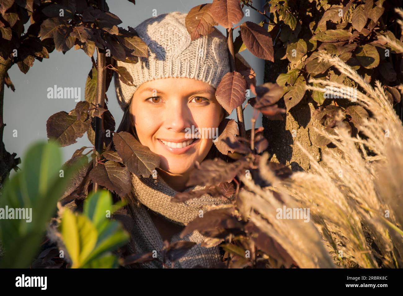 Beautiful woman wearing a warm knitted woolly cap standing smiling in a ...