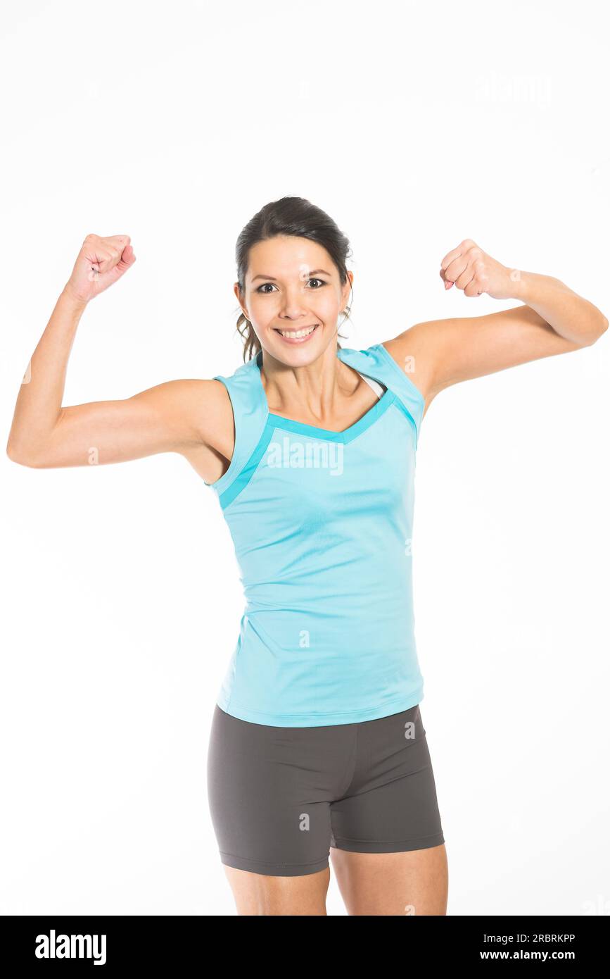 Jubilant young woman rejoicing raising her fists in the air with a ...
