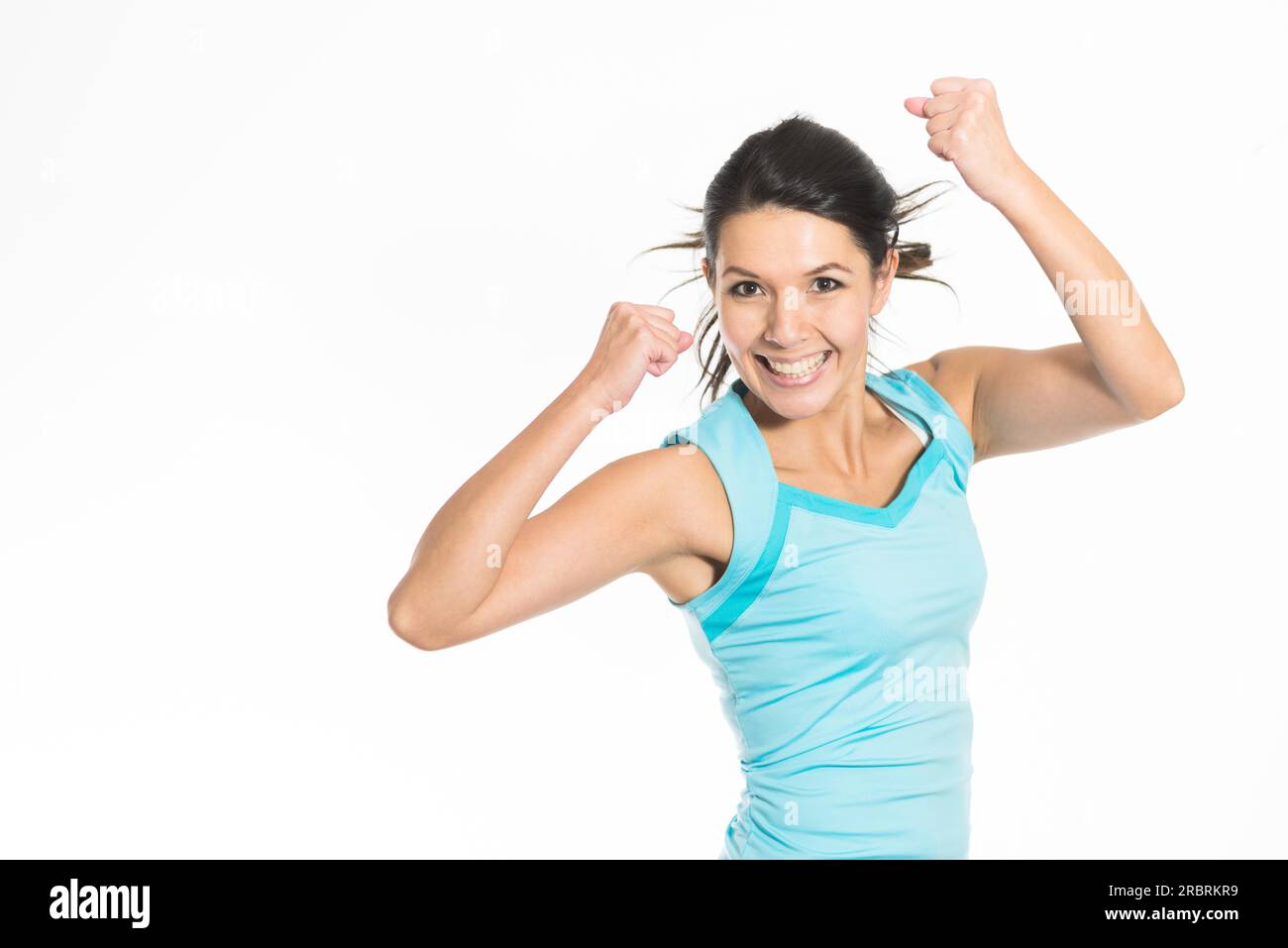 Jubilant young woman rejoicing raising her fists in the air with a ...