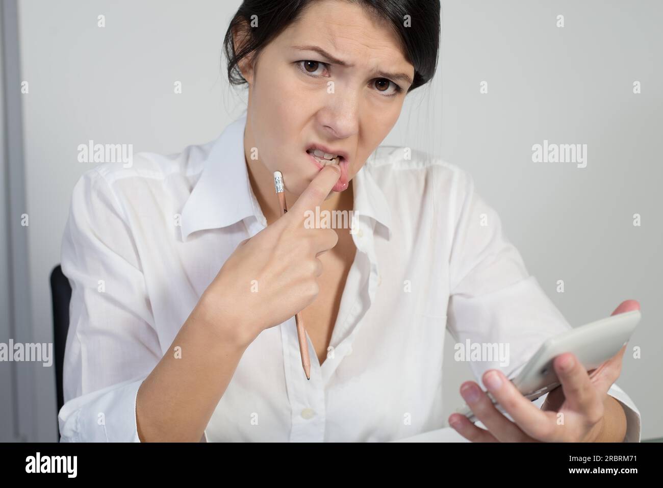 Puzzled woman thinking hard and grimacing as she tries to find an ...