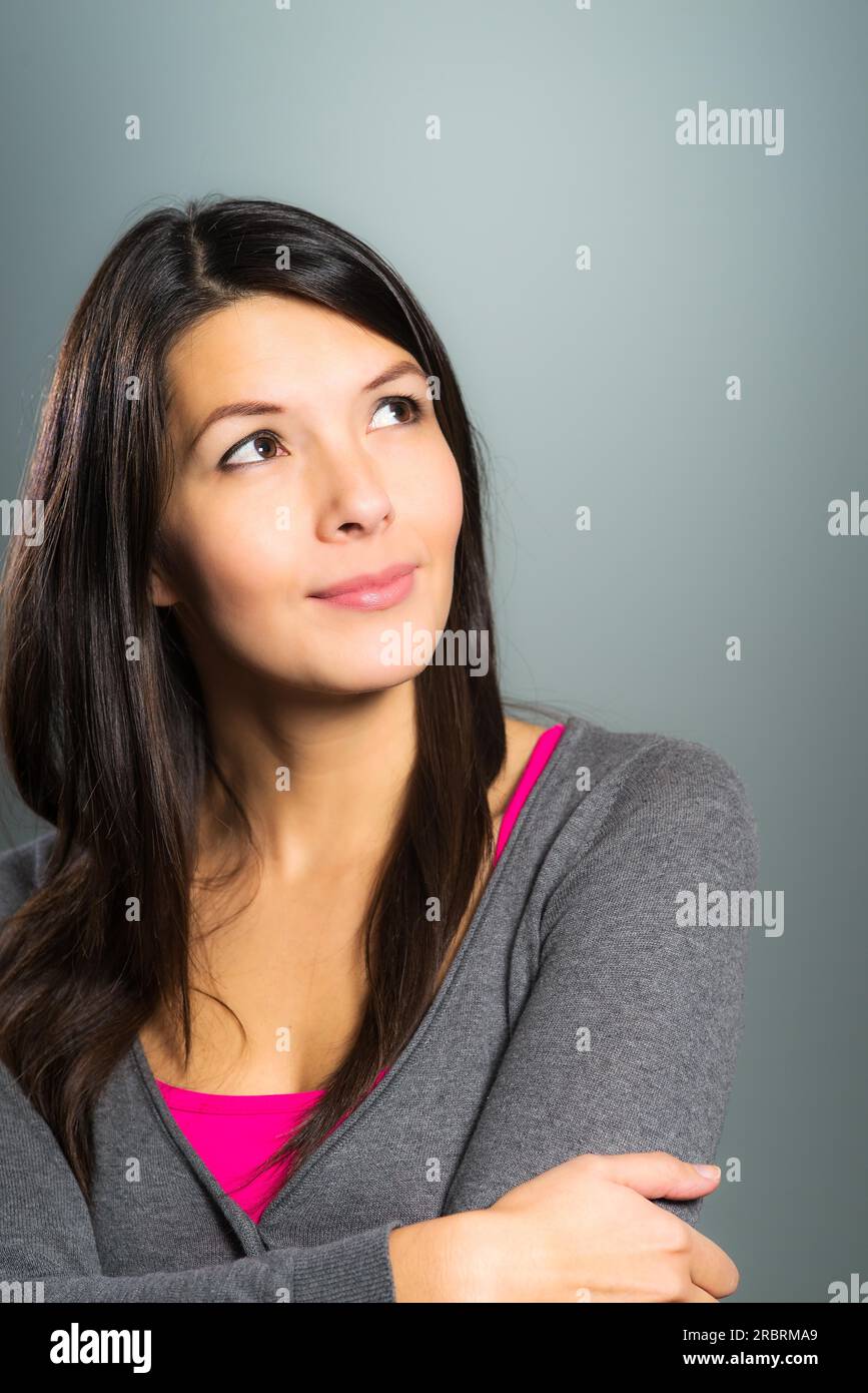 Attractive creative woman using her imagination sitting in deep thought ...