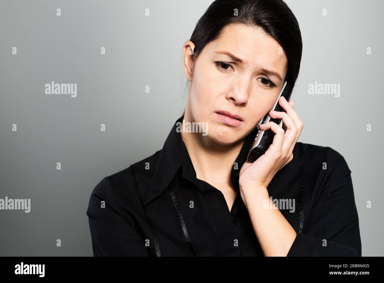 Attractive woman listening to a conversation on her mobile phone or ...