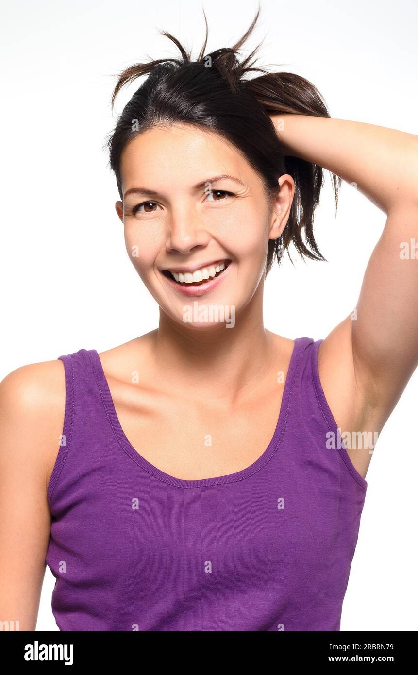 Laughing vivacious natural woman with her hand to her tousled brown ...