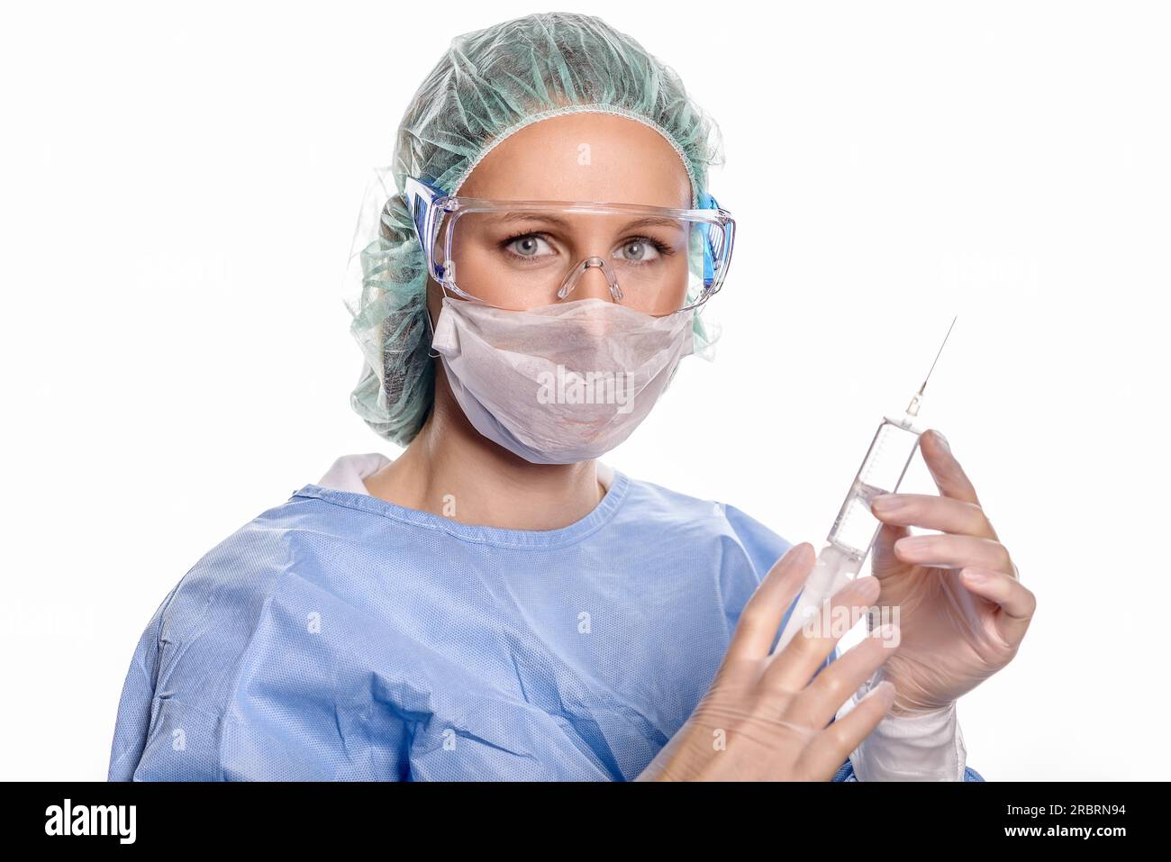Female doctor or nurse in a gown, goggles, cap, and mask ready to give ...