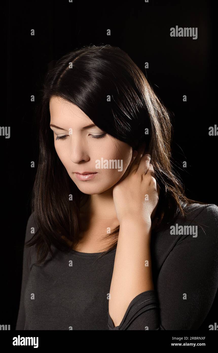 Melancholy depressed young woman with a serious expression and downcast ...