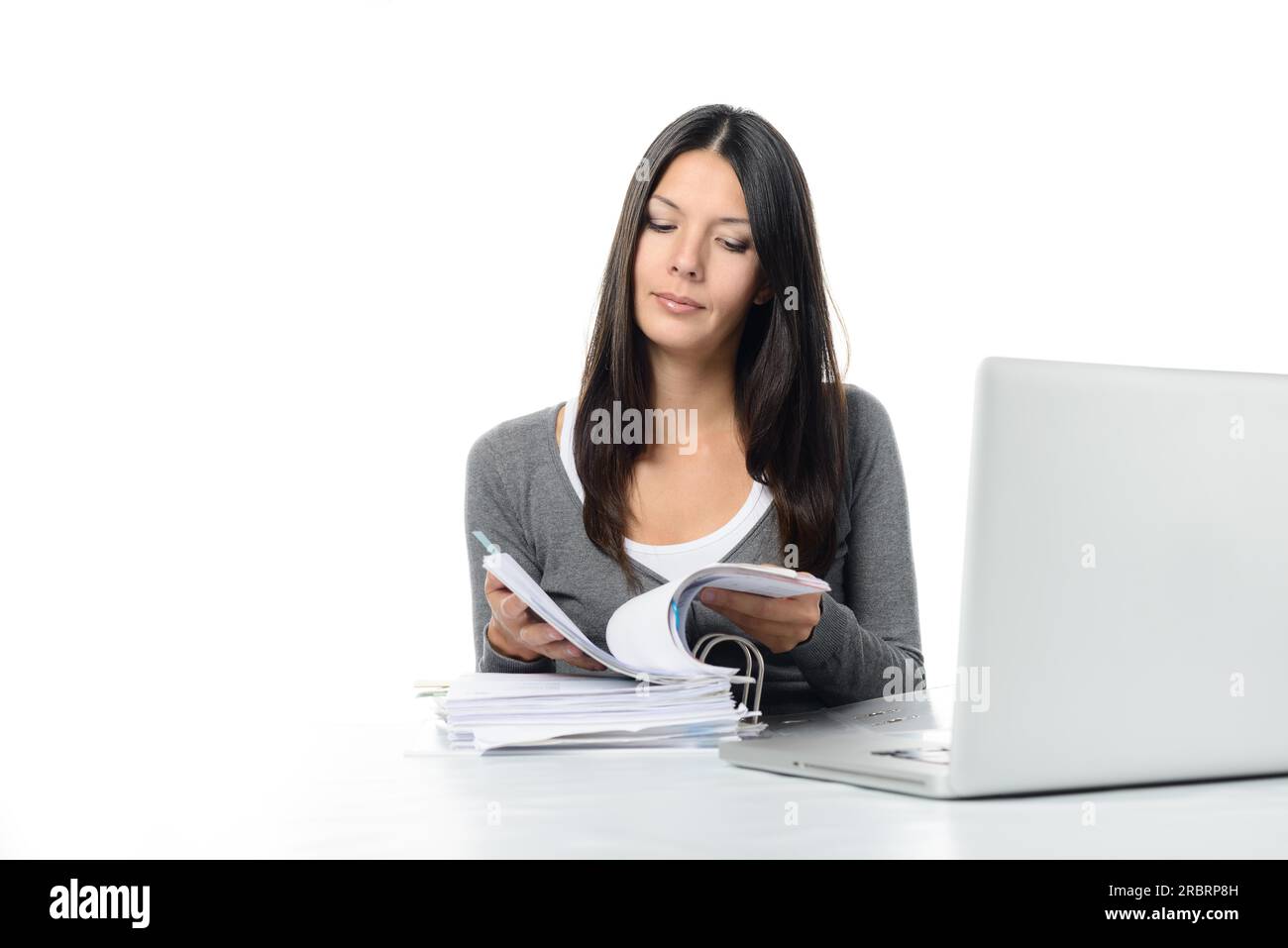 Serious Young Attractive Woman Scanning a binder While Researching at ...