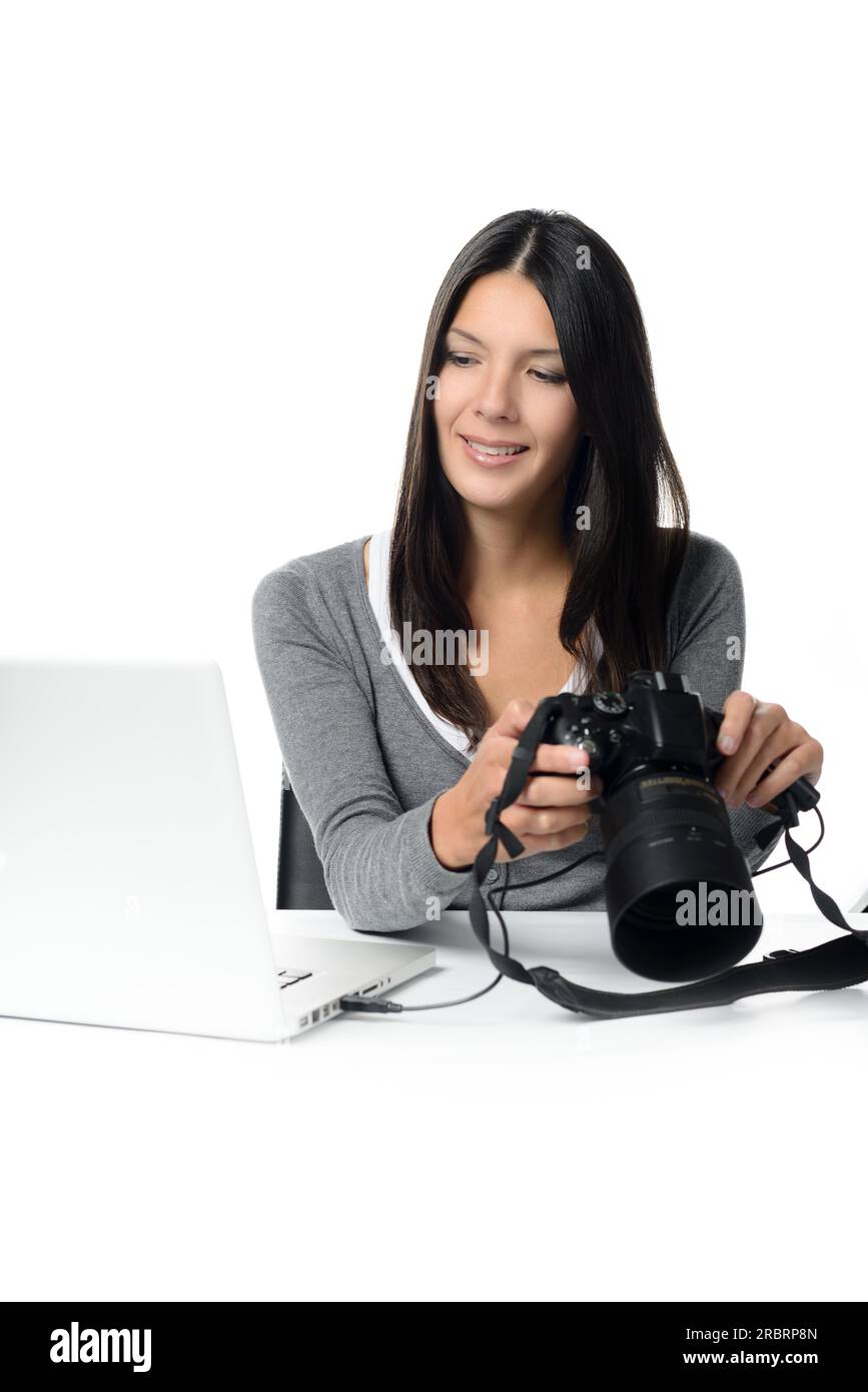 Attractive young female photographer checking an image on the back of ...