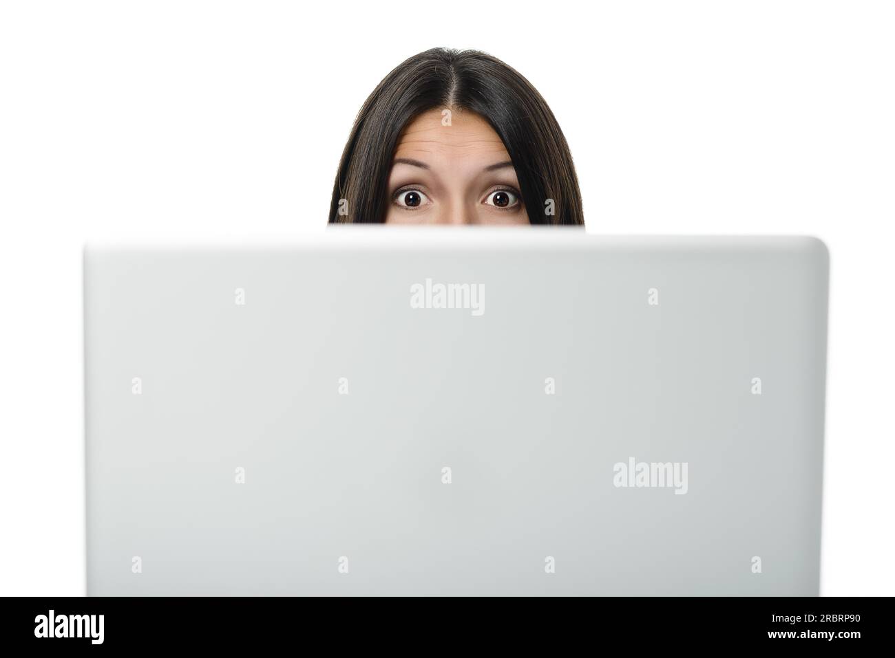 Businesswoman looking over the top of her computer screen at the camera ...