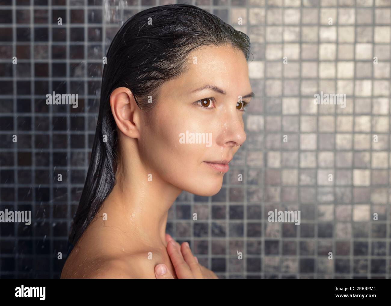 Attractive woman washing her hair in the shower rinsing it off under ...