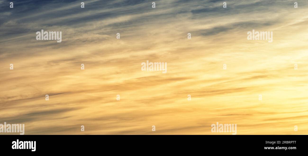 Evening Cloudscape with wispy white cirrus clouds in an orange blue sky ...