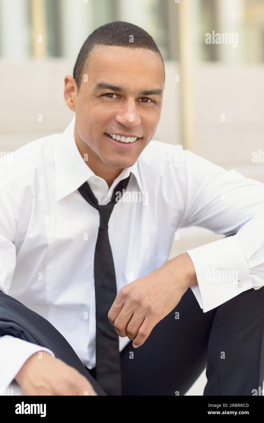 Attractive smiling businessman with a loosened tie and his collar ...