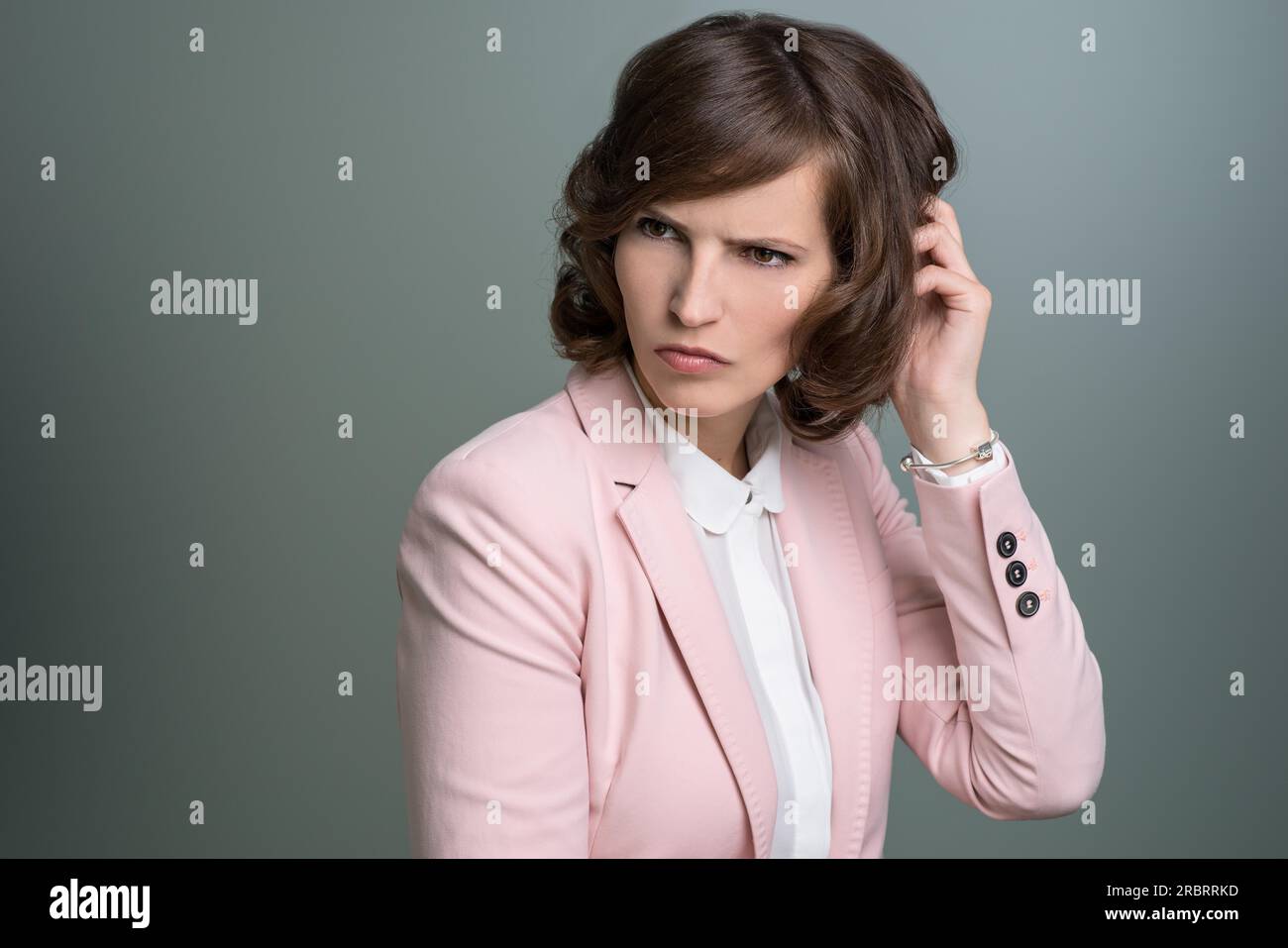Attractive young brunette businesswoman in a stylish pink jacket ...