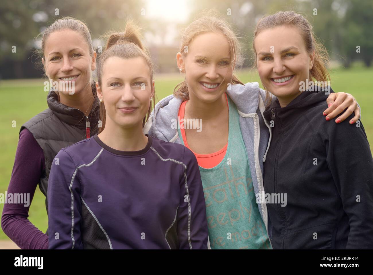 Four Happy Healthy Young Women in Line, embracing each other smiling at ...