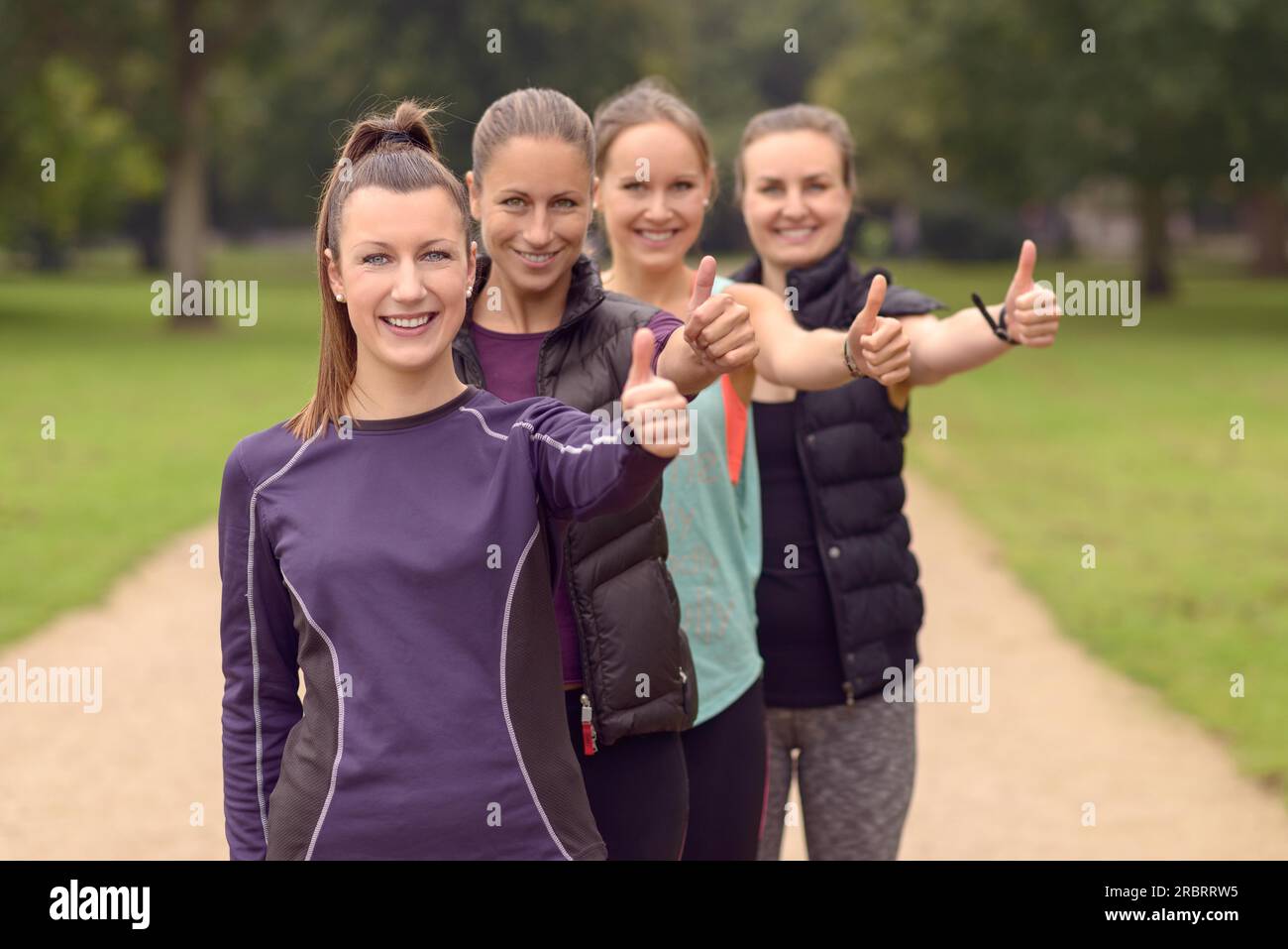 Four Happy Healthy Young Women in Line, Showing Thumbs Up at the Camera ...