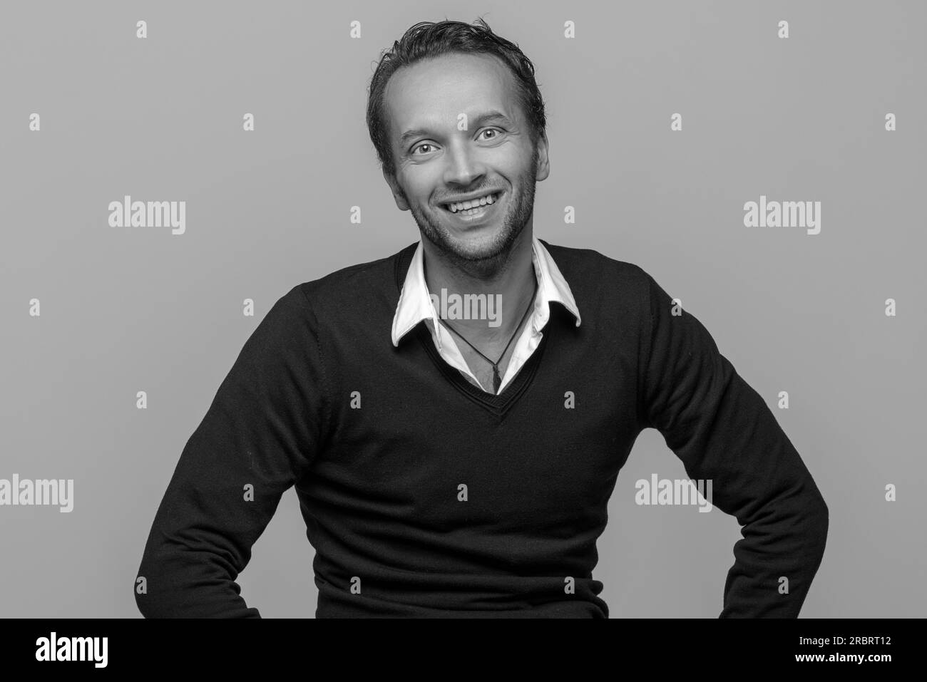 Friendly attractive man with stubble beard looking at the camera with a ...